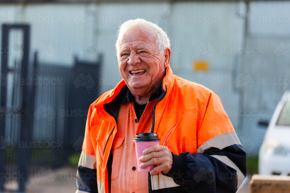 Image of Laughing older Aussie workman in high vis on cold morning with ...