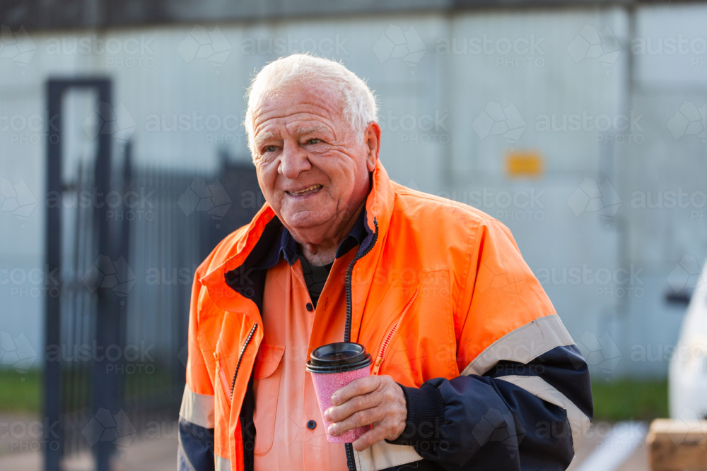Image of Laughing older Aussie workman in high vis on cold morning with ...