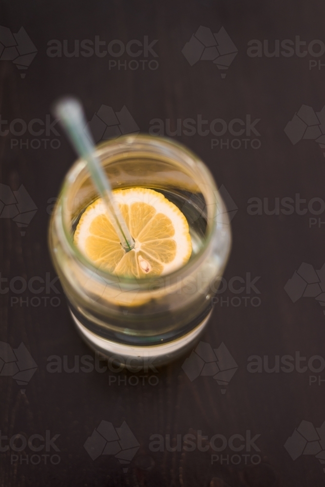 Image of lemon water in a jar with a straw through the lemon slice ...