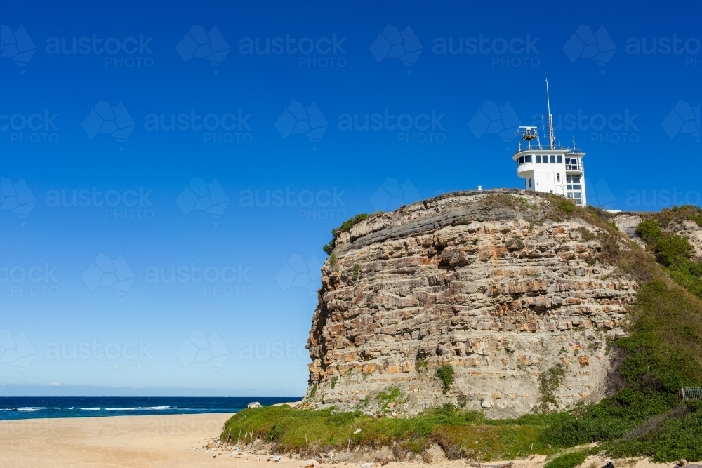 Image of lighthouse on cliff in Newcastle with deep blue sky and beach ...