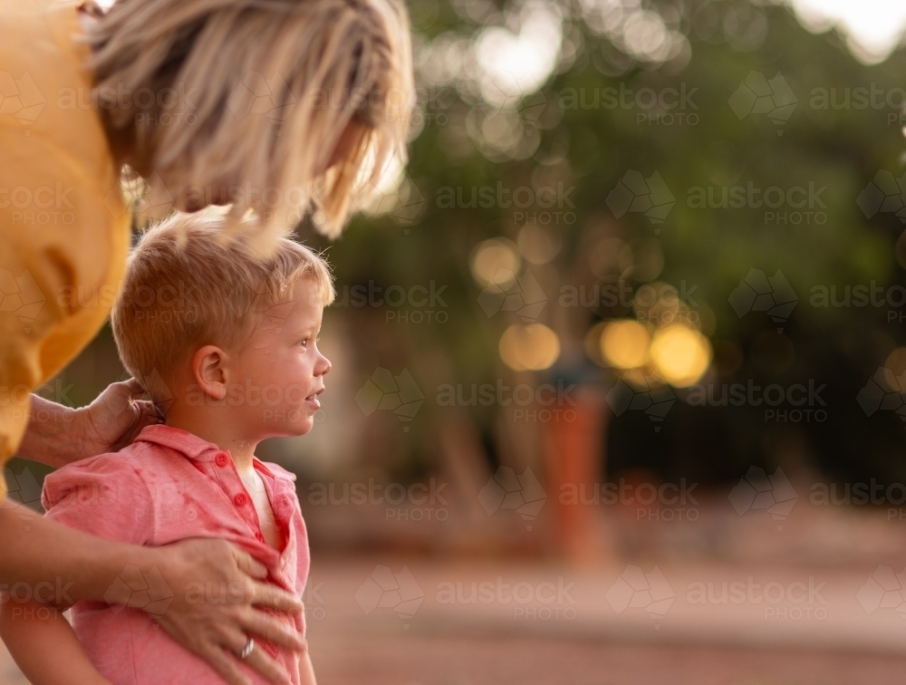 Image of little boy being restrained by his mother with her hand on his ...