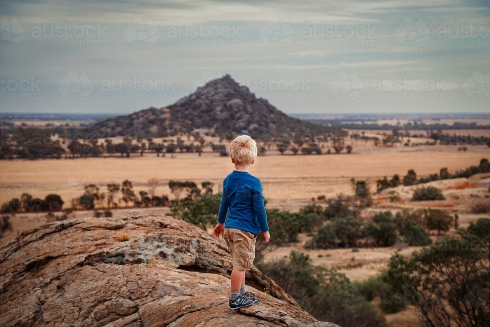Image of Little boy standing on rock looking towards Pyramid Hill in ...