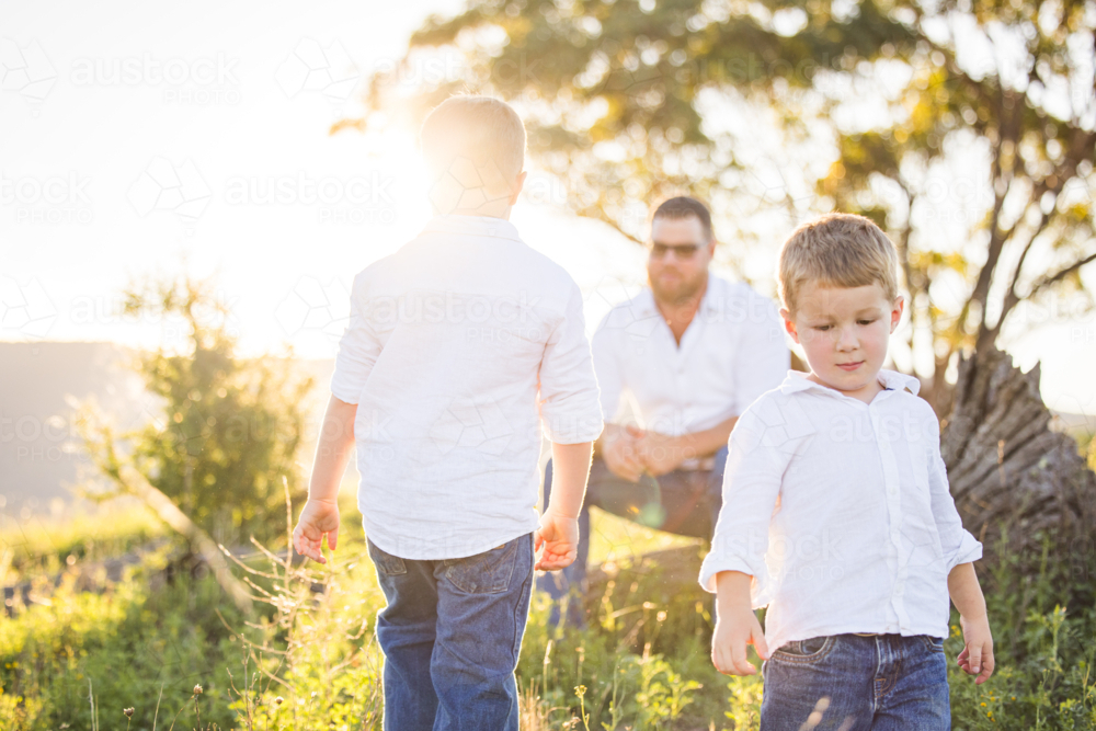 Image of Little boys exploring farm in bright afternoon sunshine with ...