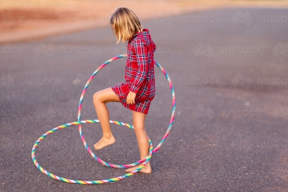 Image of little girl playing with hoops outside - Austockphoto