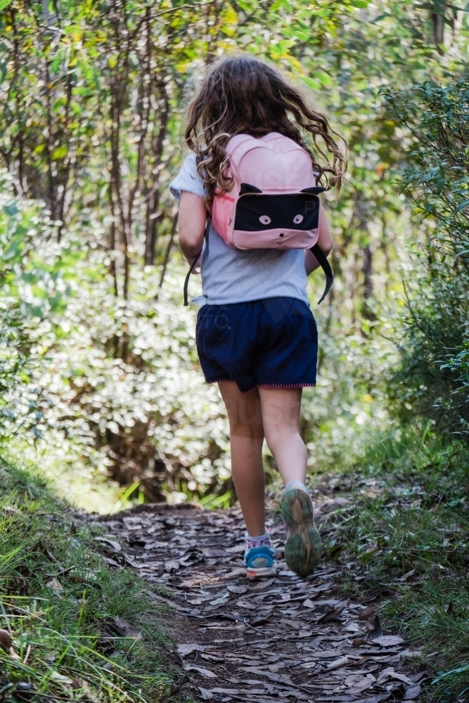 Image of Little girl runs through the bush track - Austockphoto