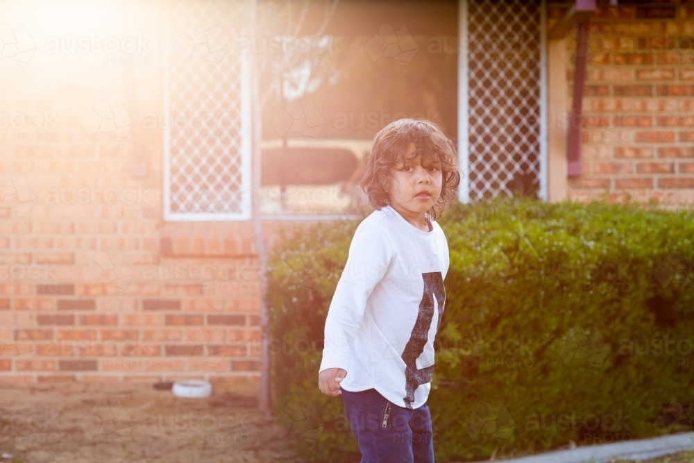 Image of Little kid outside his suburban home - Austockphoto