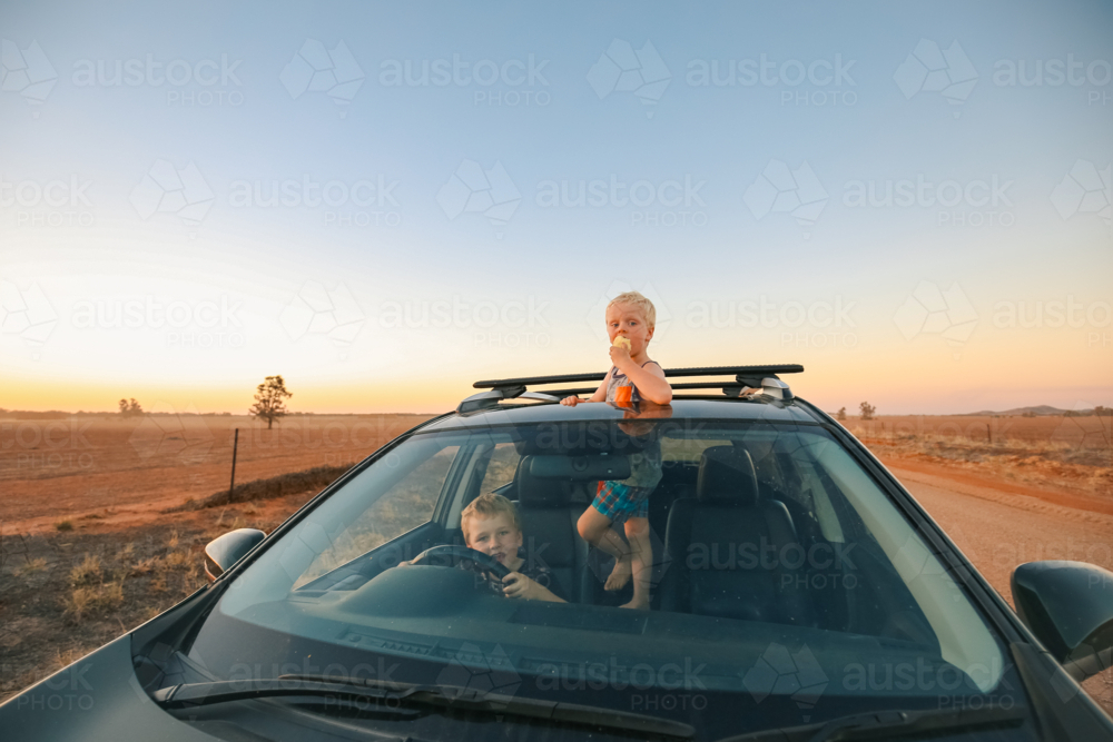 Image of Little kids hanging out in car with one sticking out sunroof ...