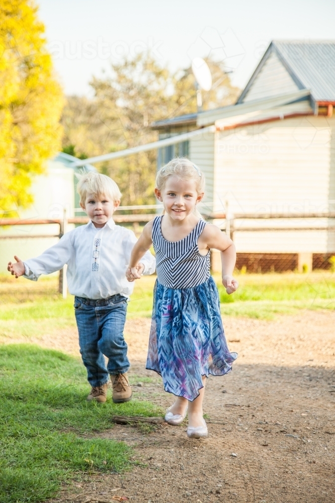 Image of Little kids running around the yard together - Austockphoto