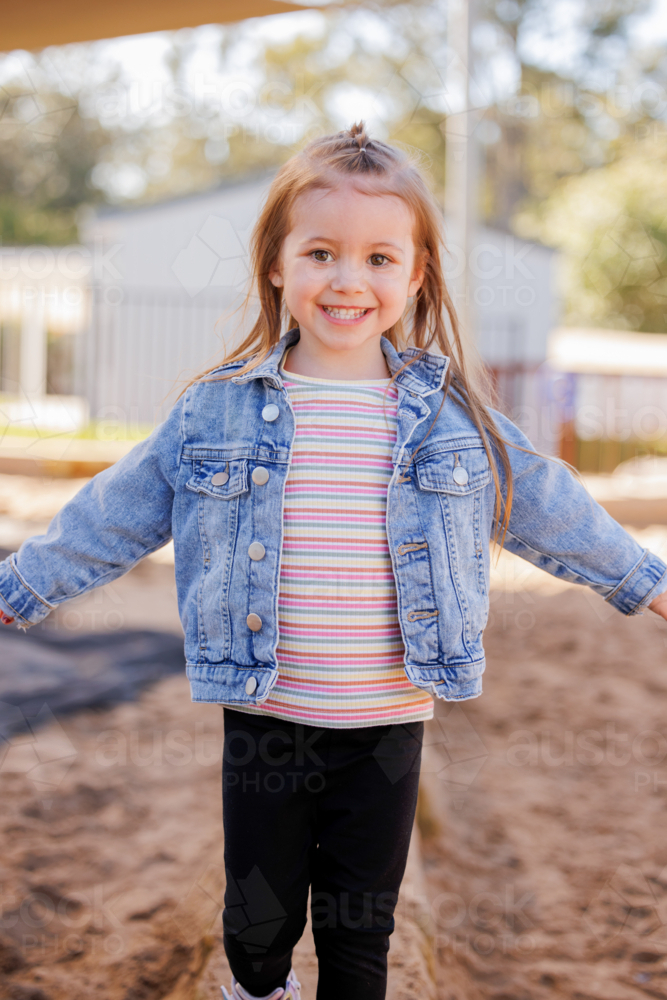 Image of Little preschool girl balancing along wall in kindergarten ...