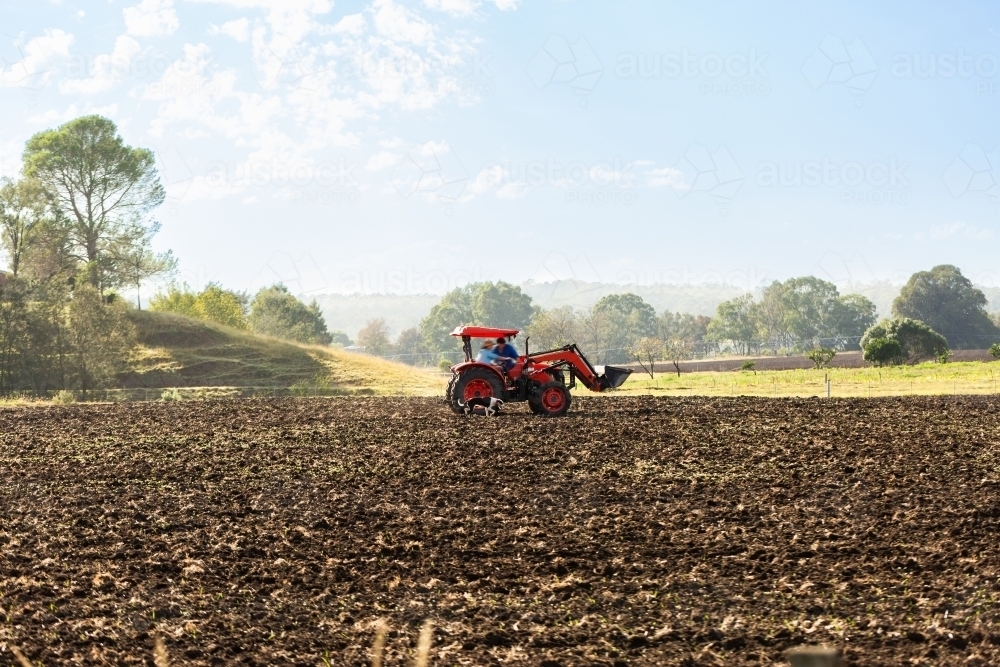 Image of Loader tractor in tilled farm paddock - Austockphoto