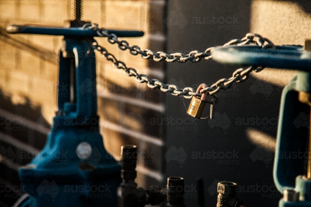 Image of Lock on wheels and chains on a blue water hydrant - Austockphoto