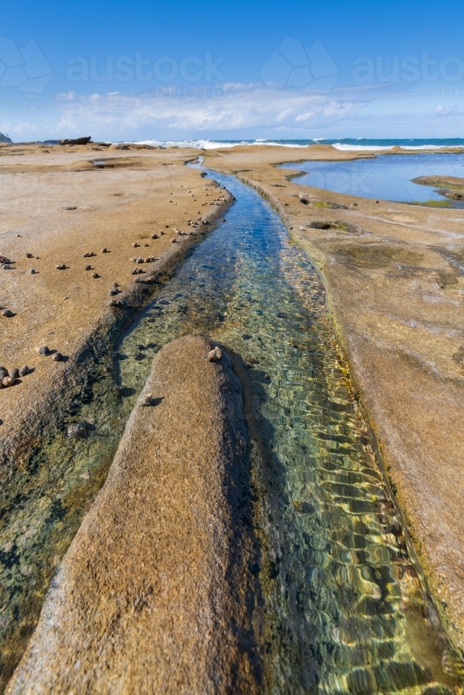 Image of Long angled view of a long narrow rock pool running towards a ...