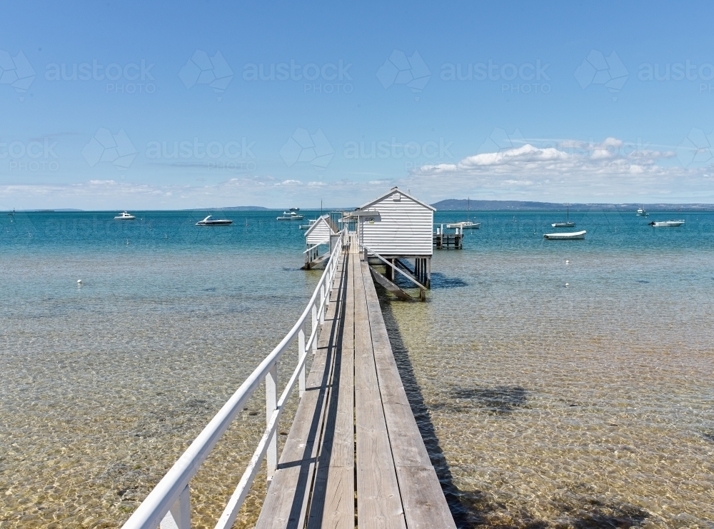 Image of Long jetty leading to a boat shed - Austockphoto