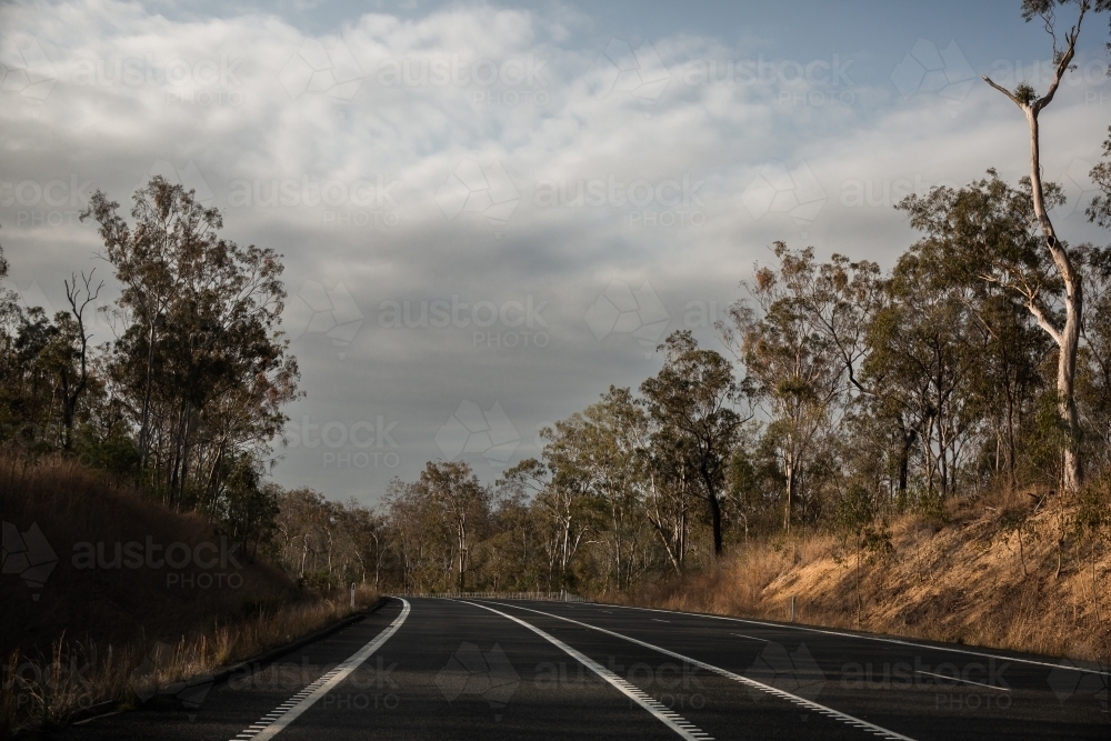 Image of looking along an empty highway in afternoon light - Austockphoto