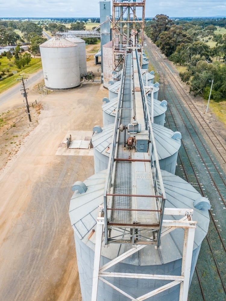 Image of Looking along the tops of a line of grain silos between a road ...