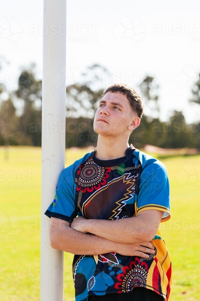 Image of Looking away portrait of young teenage sports player leaning ...