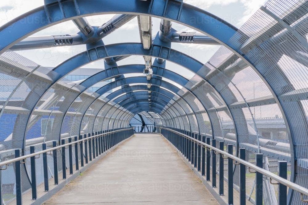 Image of Looking down a tubular metal walkway with steel girders and ...