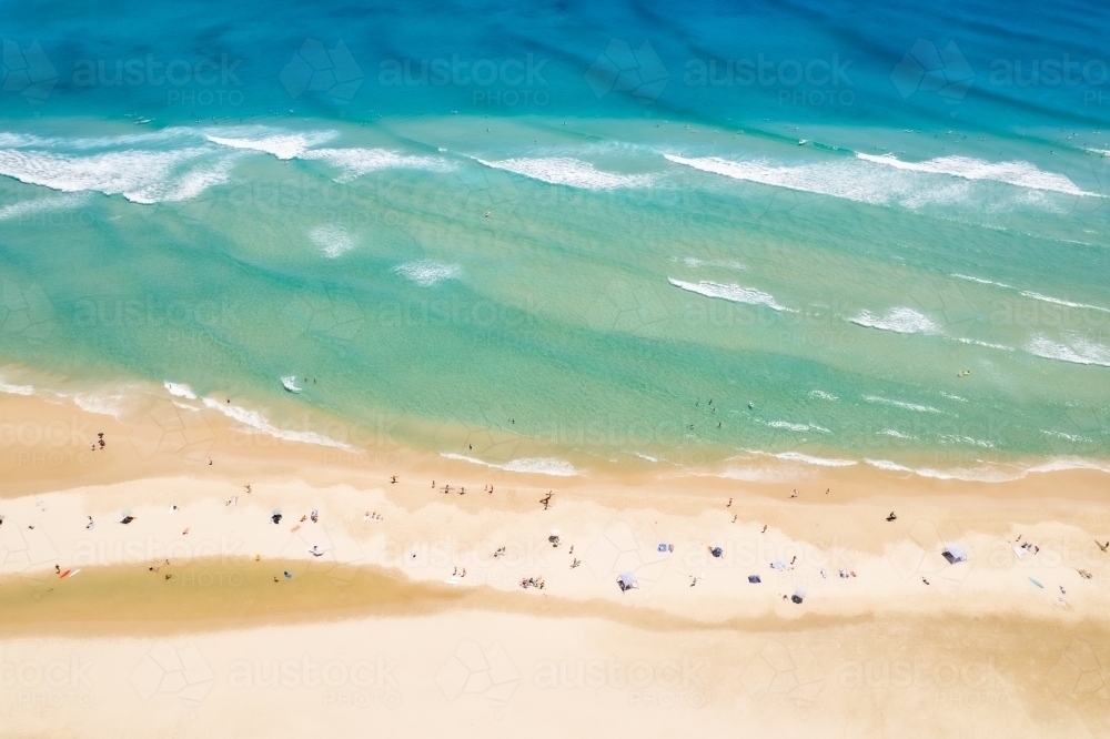 Image of Looking down on a populated beach of swimmers - Austockphoto