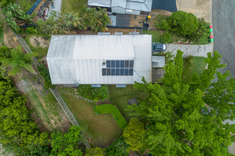 Image of Looking down on house with solar panels on metal roof ...