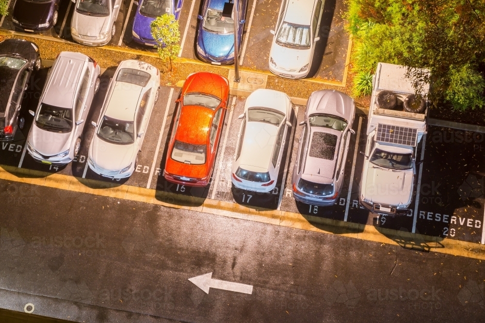 Image of Looking down onto the tops of cars in a carpark on a wet night ...