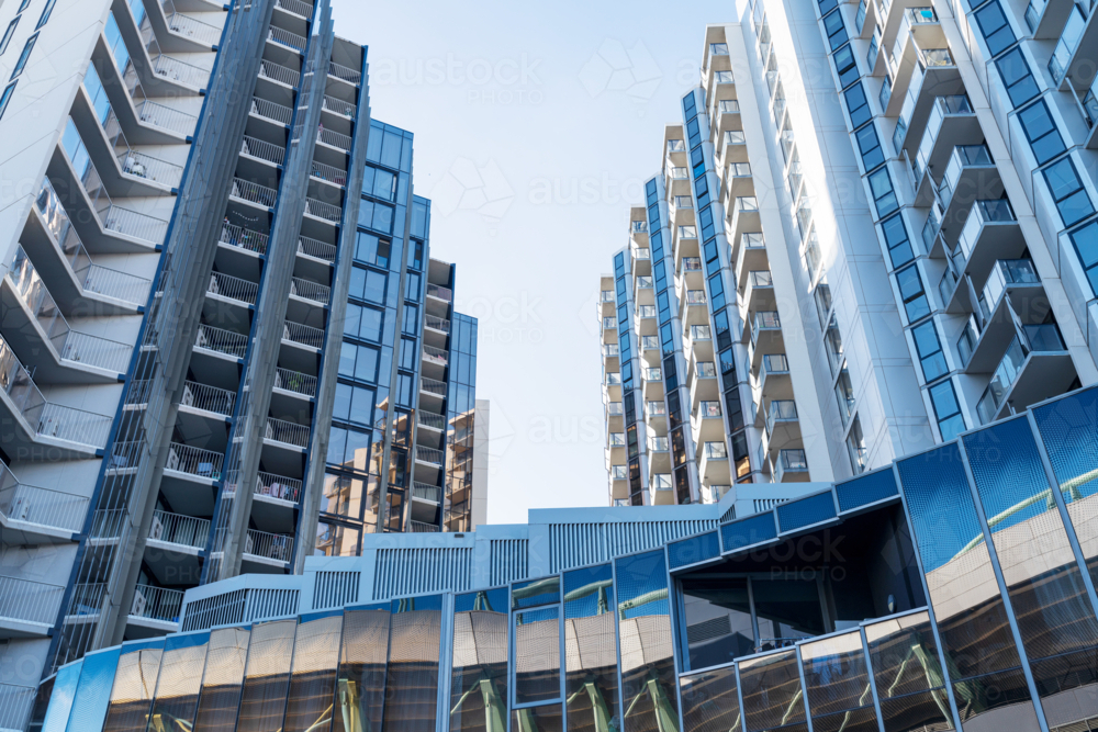 Image of Looking up at high-rise buildings of glass and balconies ...