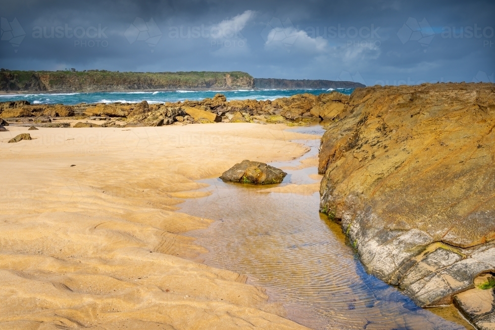 Image of Low angle view of a dark sky over a rugged coastline with a ...