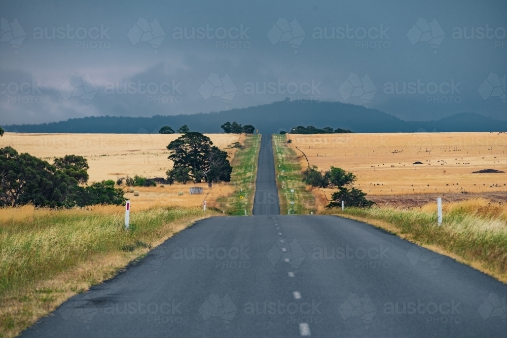 Image of Low angled view of a bitumen road leading into heavy rain ...