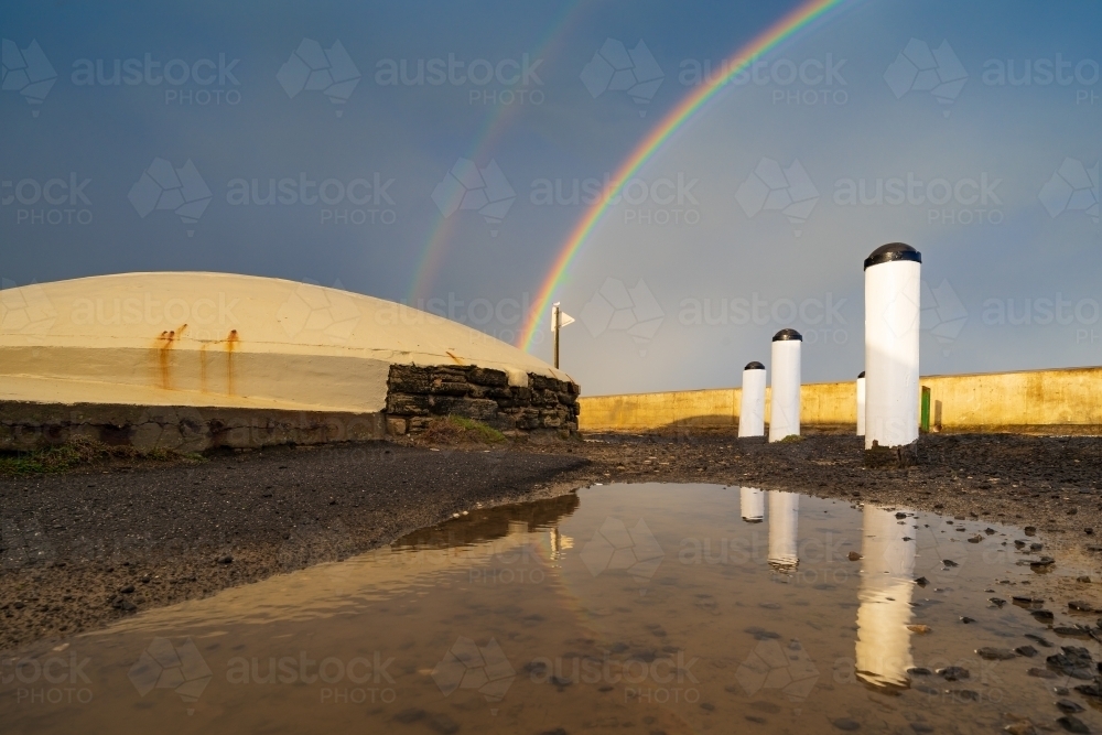 Image of Low angled view of white bollards a double rainbow above all ...