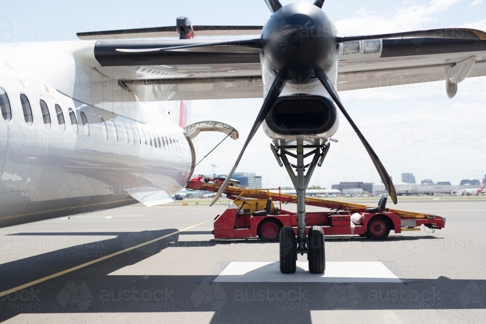 Image of Luggage being loaded onto a plane with a propeller in ...