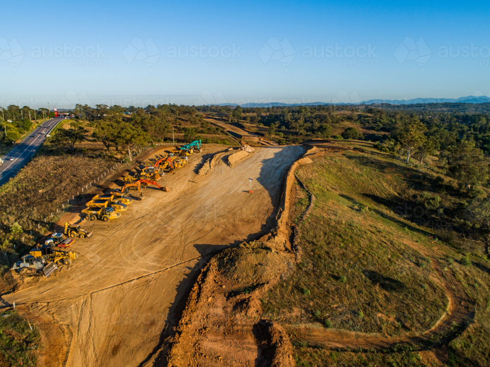 Image of Machinery on worksite lined up in morning light ready to ...