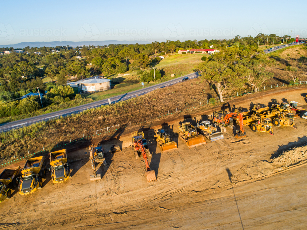 Image of Machinery on worksite lined up in morning light ready to ...