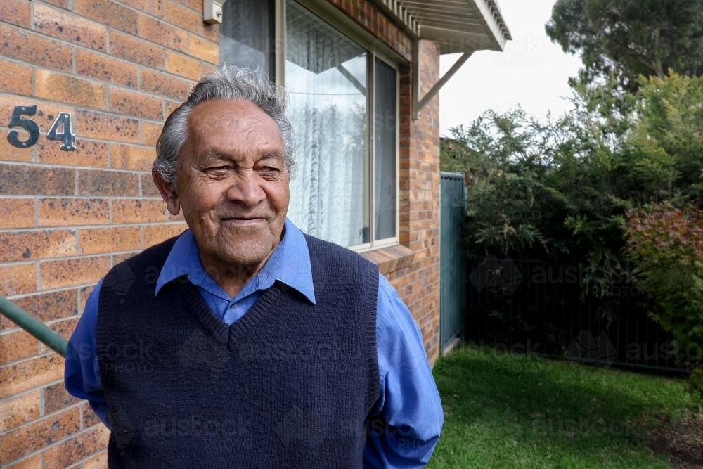 Image of Male Aboriginal elder standing in front of his home - Austockphoto