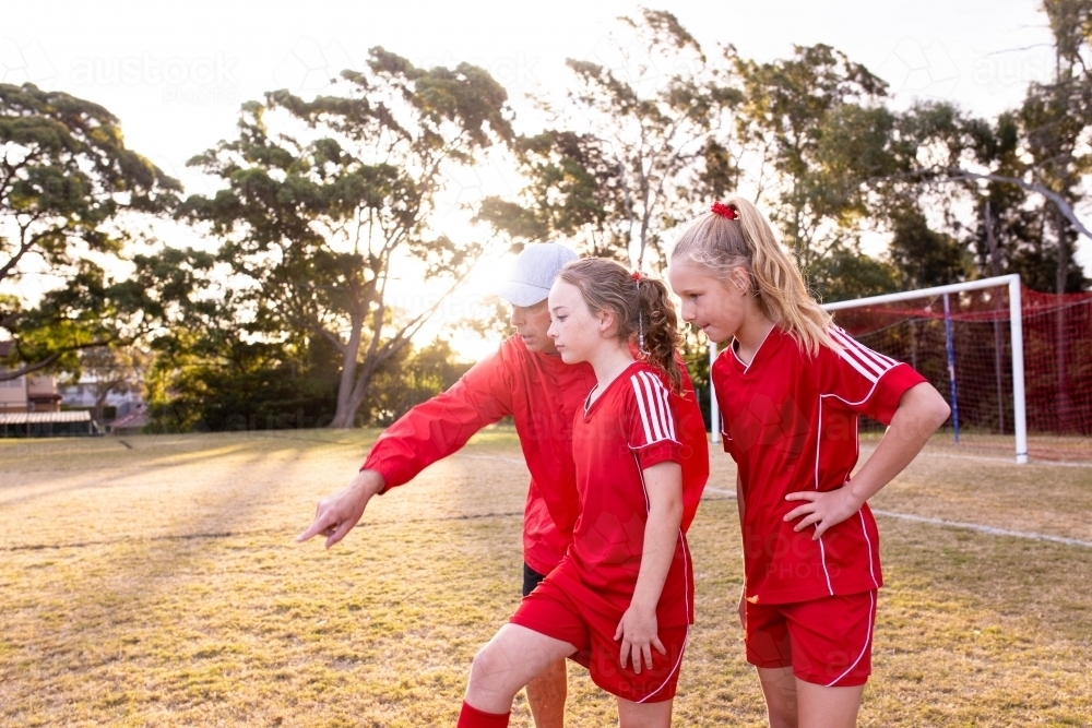 Image of Male coach standing and teaching tween girls as they train for ...