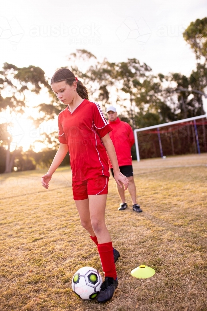 Image of Male coach standing and teaching tween girls as they train for ...
