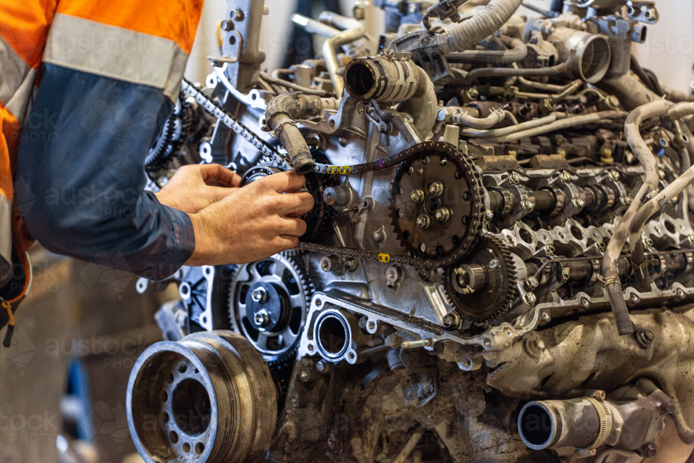 Image of Male mechanic working on a complex engine inside industrial ...
