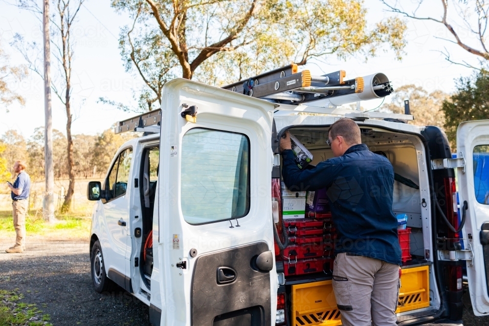 Image of Male tradie and his work vehicle - electrician - Austockphoto