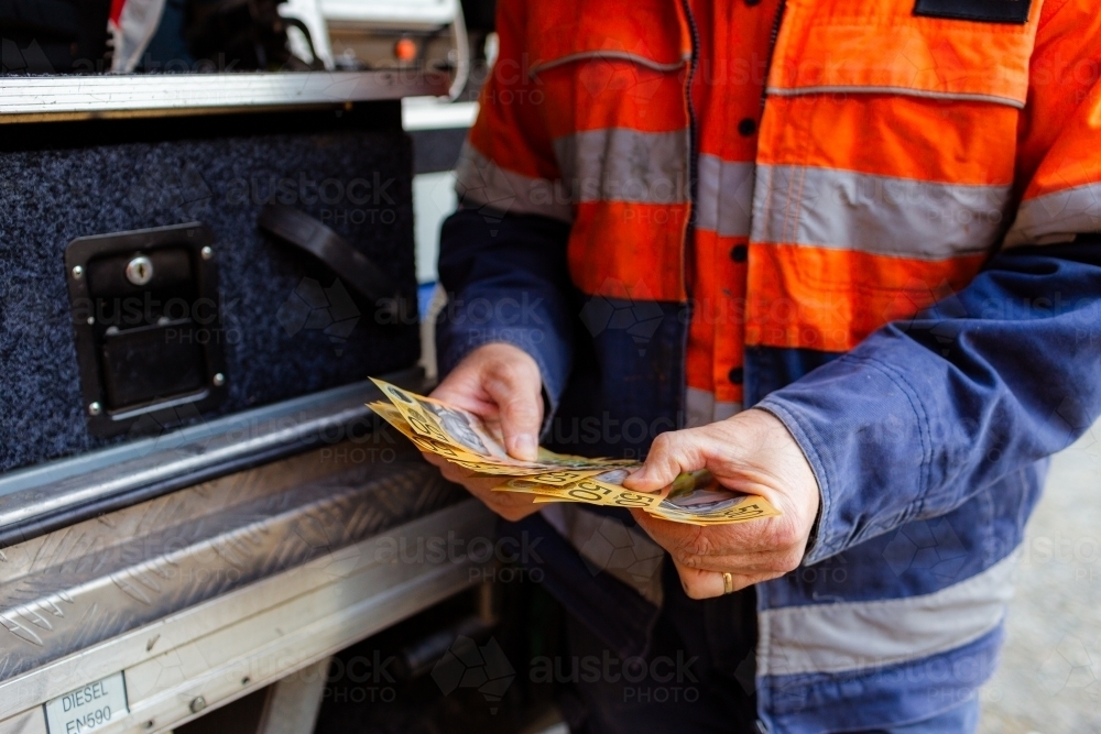 Image of Male tradie counting cash payment for job paid in cash ...