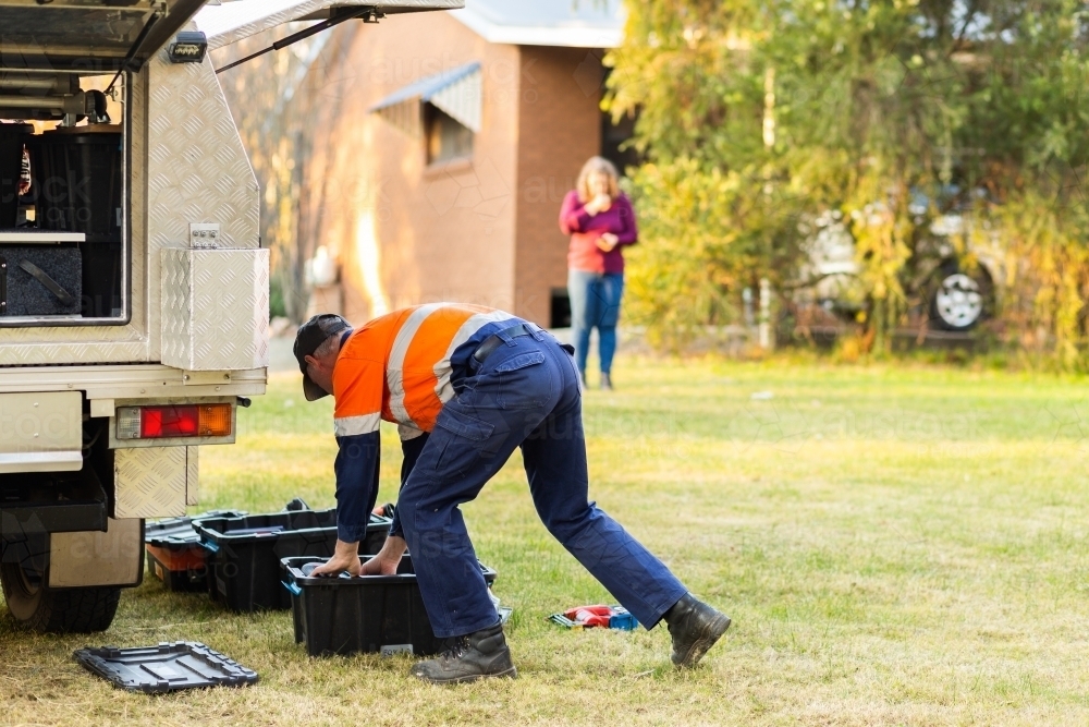 Image of male tradie opening box of tools beside ute to work on rural ...