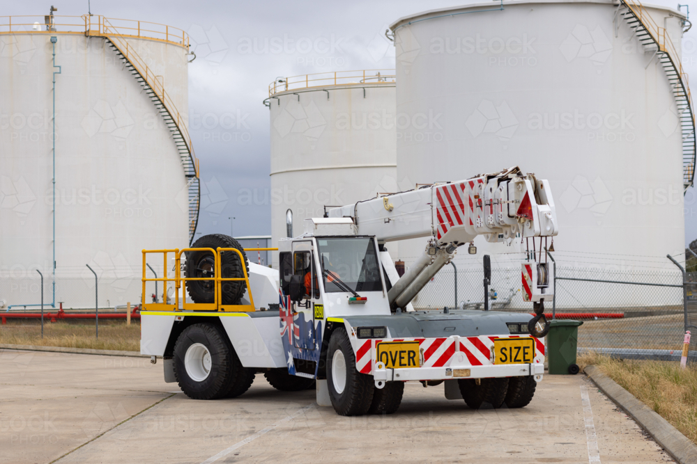 Image of Male worker driving oversize crane truck on industrial site ...