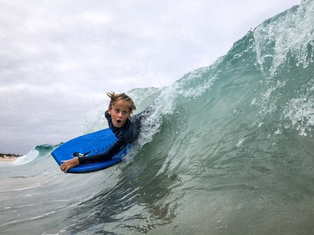 Image Of Male Youth Surfing Wave On Boogie Board In Ocean Austockphoto