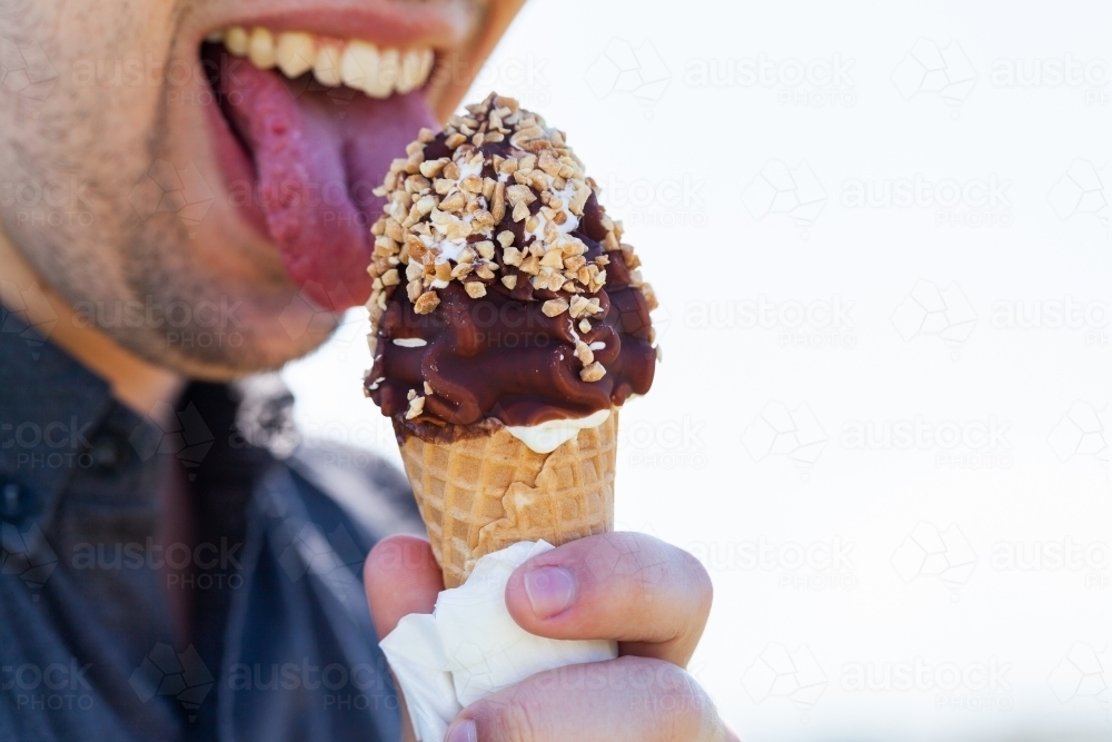 Image of man about to eat soft serve ice cream with choc nut toping on ...