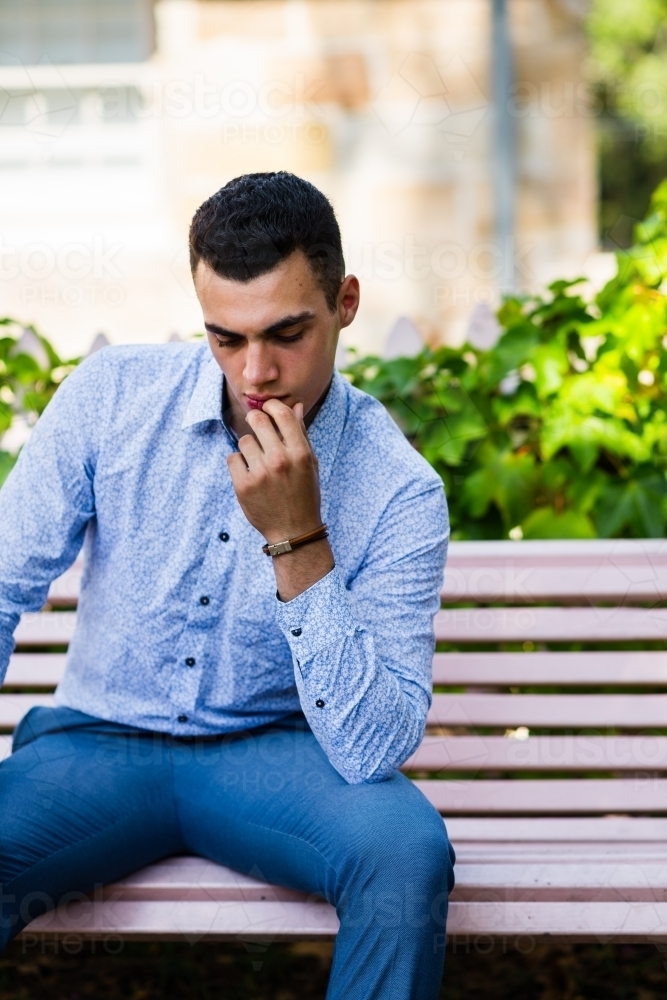 Image of man alone on park bench in a park - Austockphoto