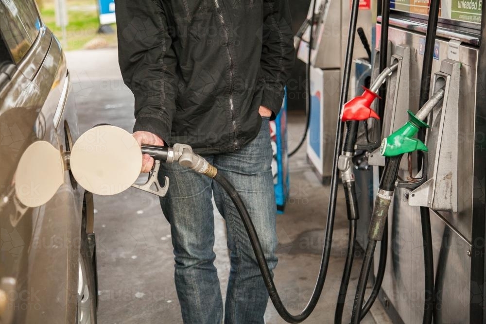 Image of Man at petrol station filling up family car with fuel ...