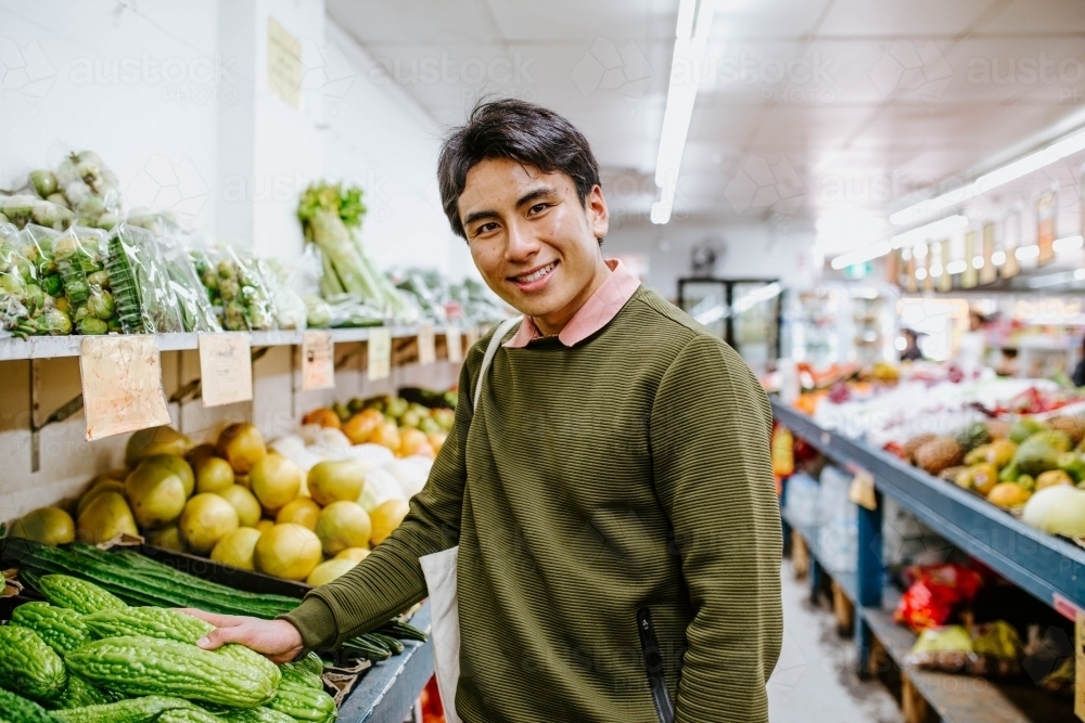 Image of Man buying fresh produce at supermarket - Austockphoto