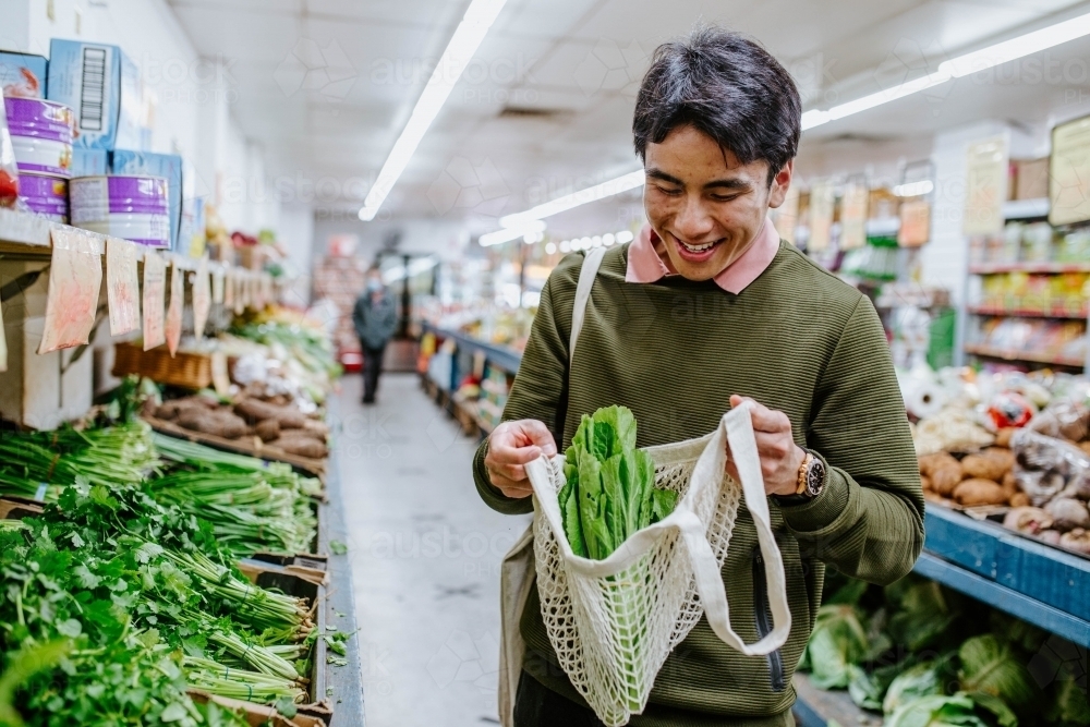 Image of Man buying fresh produce at supermarket - Austockphoto