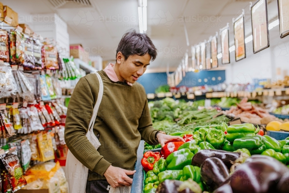Image of Man buying fresh produce at supermarket - Austockphoto
