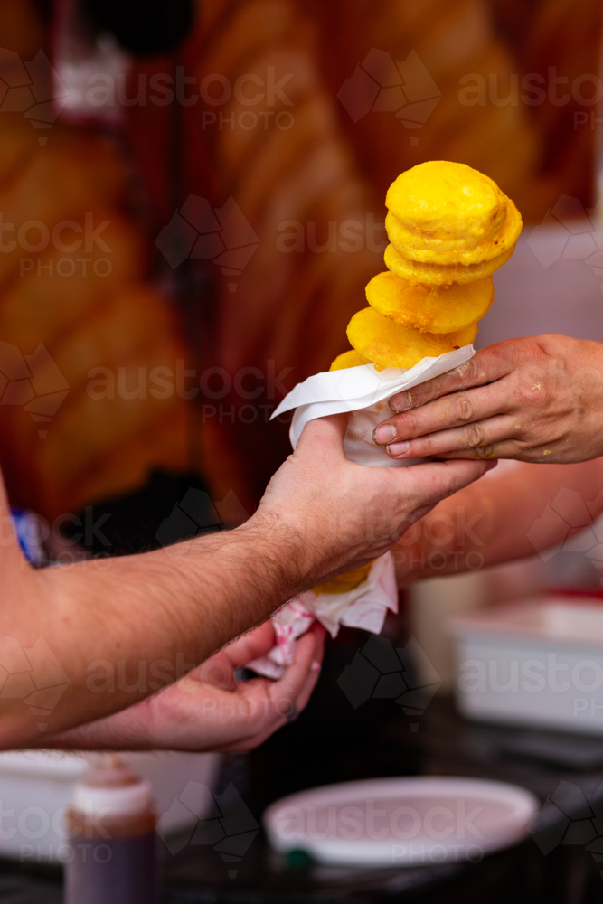 Image of Man buying spiral potato chips on a stick at local show event ...