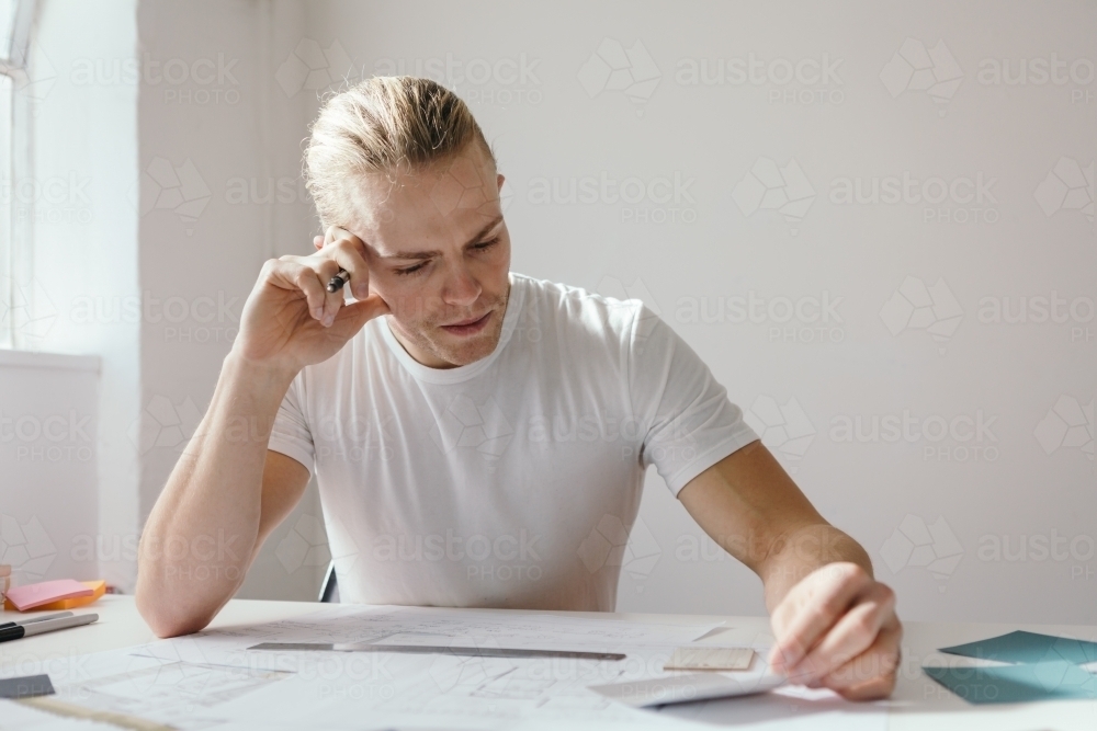 Image of Man frowning and deep in thought at work - Austockphoto
