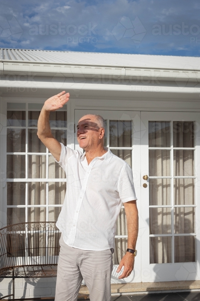 Image of Man holding hand to block light on deck - Austockphoto