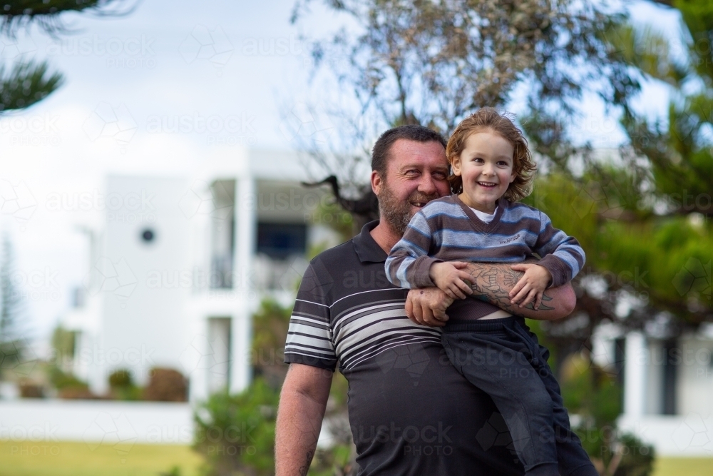 Image of man holding up young child - Austockphoto